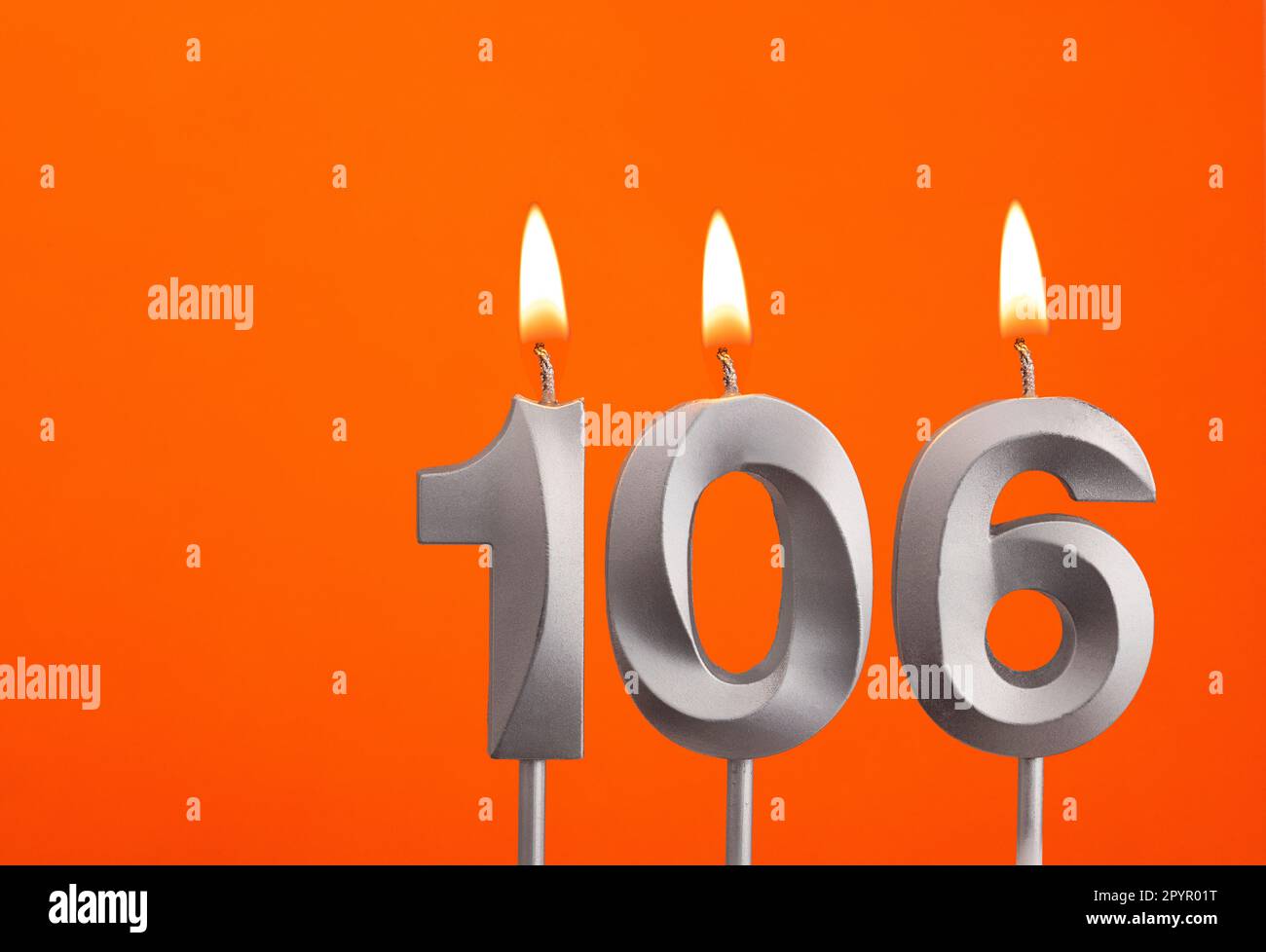 Candle number 106 - Birthday in orange background Stock Photo - Alamy