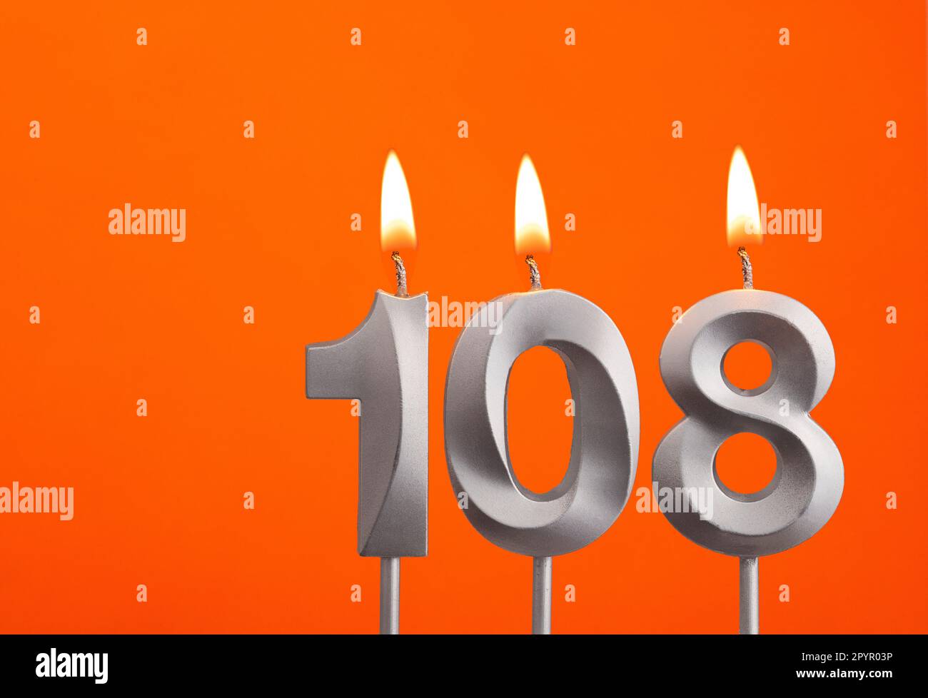 Candle number 108 - Birthday in orange background Stock Photo - Alamy