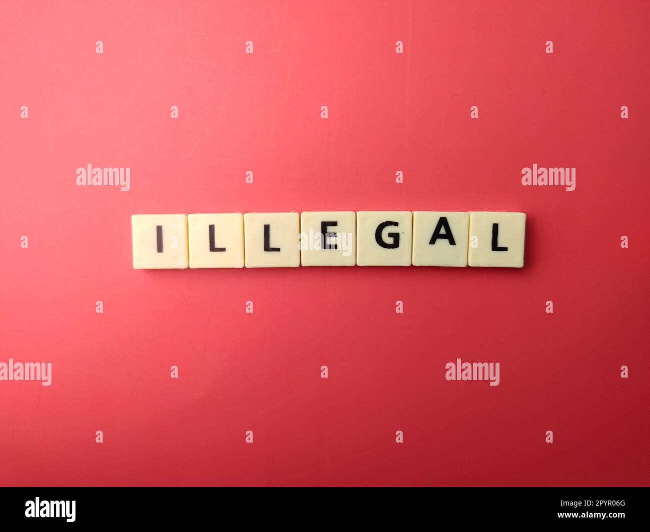 Top view toys word with the word ILLEGAL on a red background Stock ...