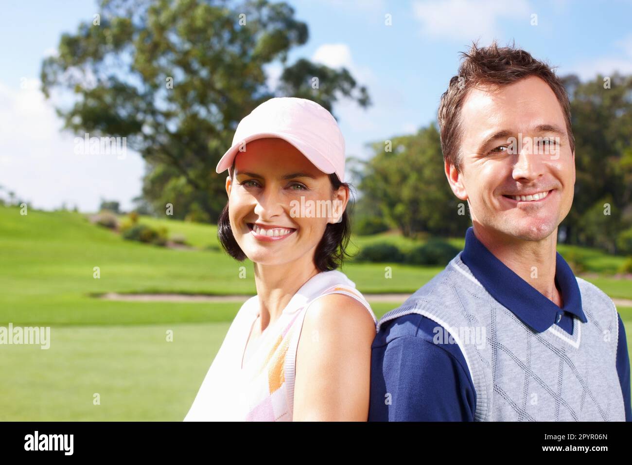 Cute golfing couple smiling. Closeup of golfing couple giving you a ...