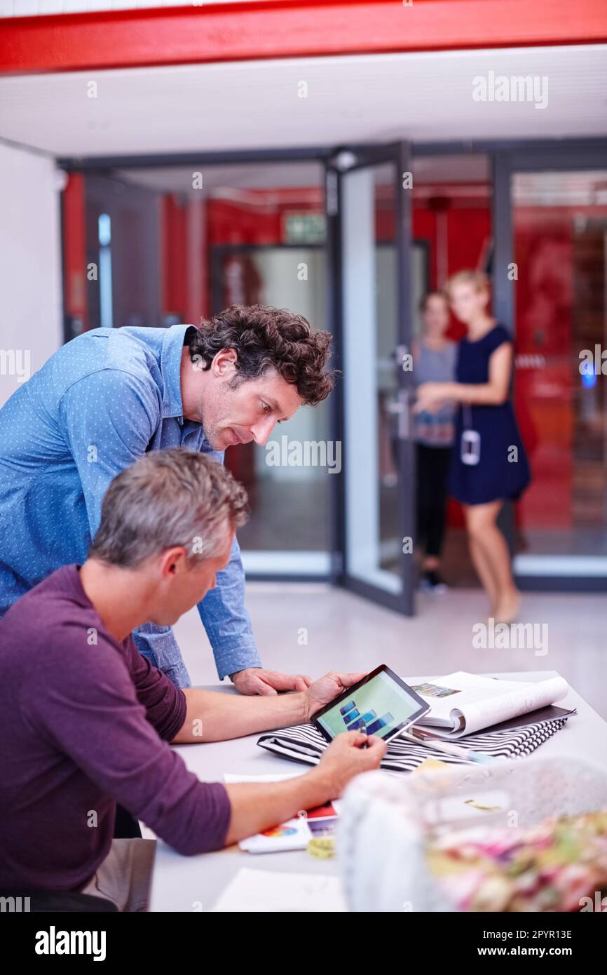 Getting a second opinion. two male coworkers at work Stock Photo - Alamy