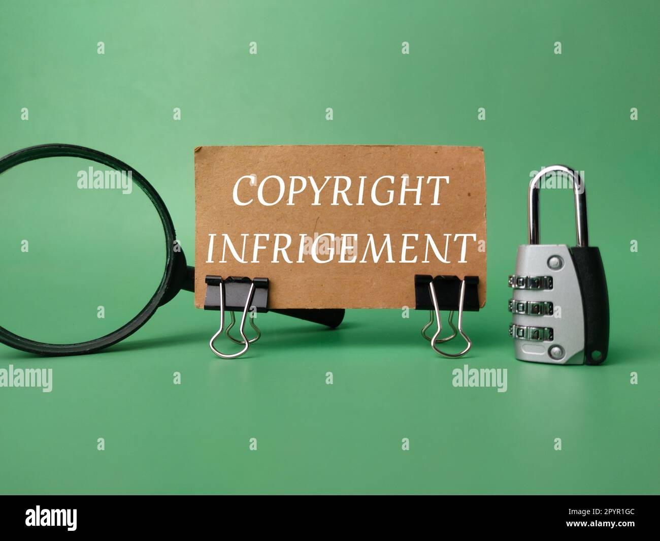 Padlock and magnifying glass with the word Copyright Infringement on ...