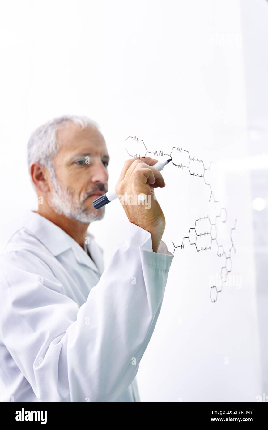 Hes got years of chemistry experience. a mature male scientist drawing ...