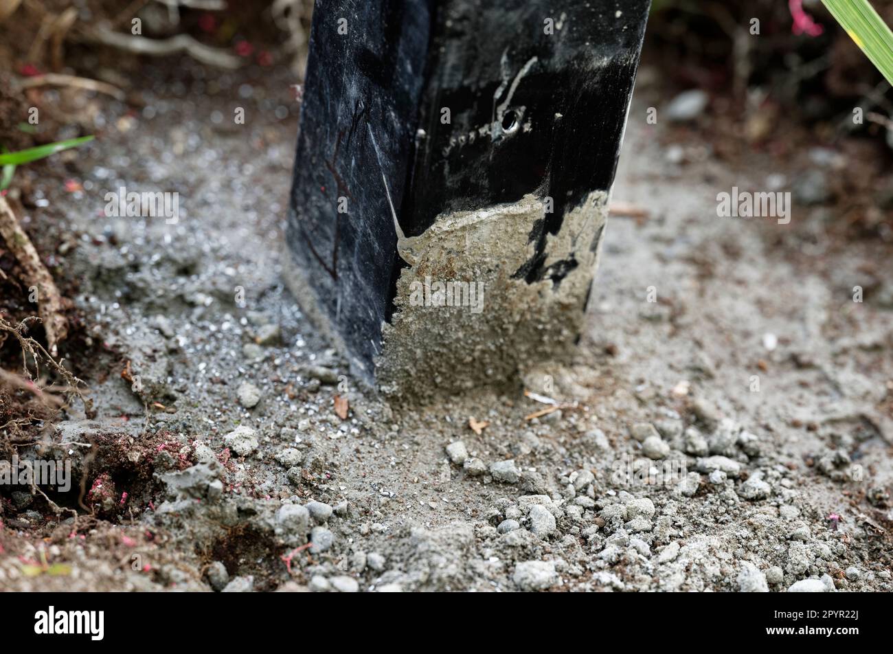 Cement has splashed up a black metal post during the construction of a ...