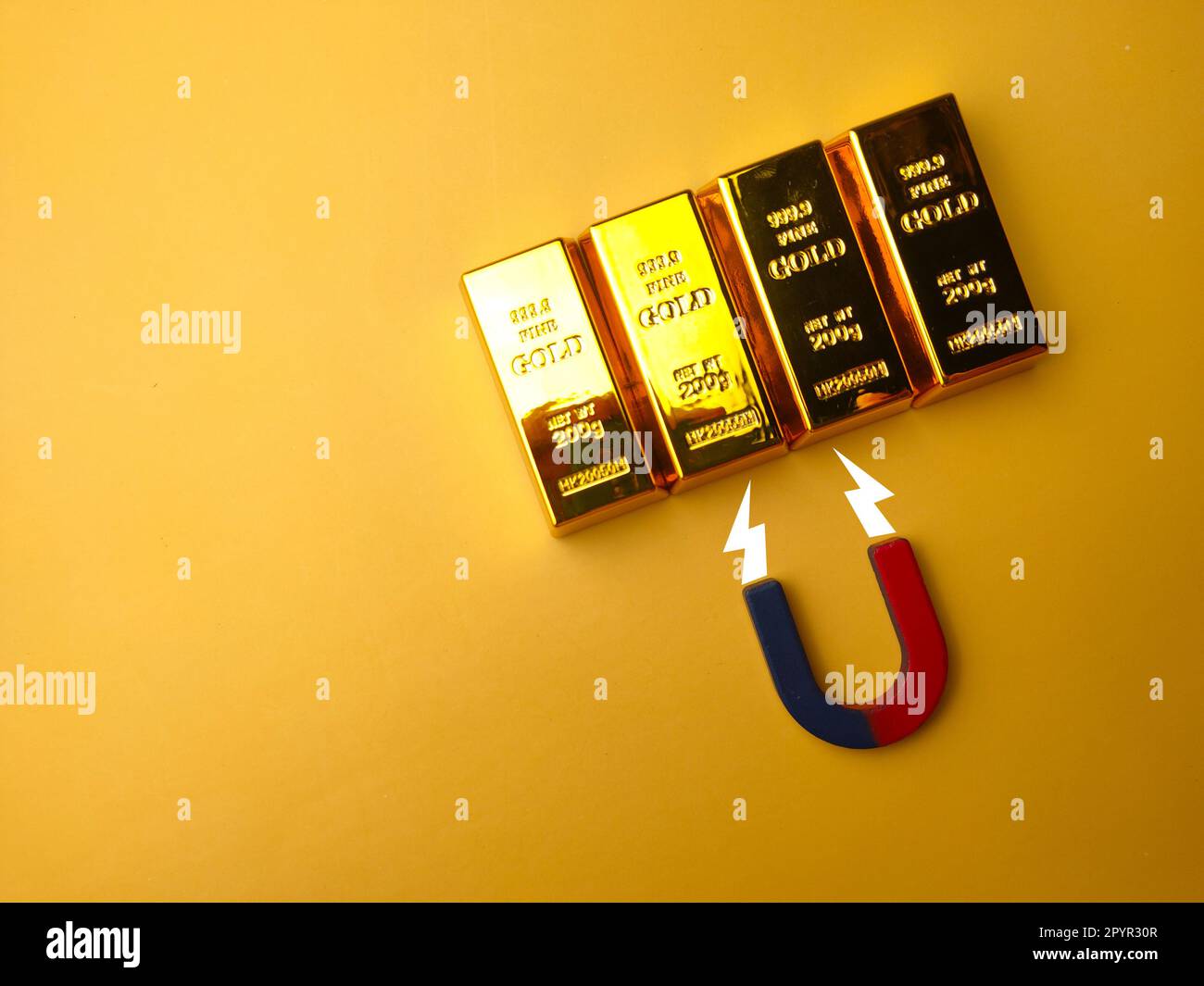 Top view magnet attract the gold bar on a yellow background Stock Photo ...