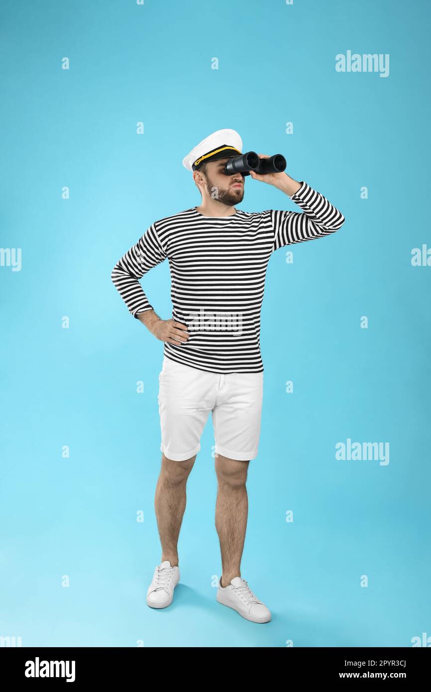 Sailor with binoculars on light blue background Stock Photo - Alamy
