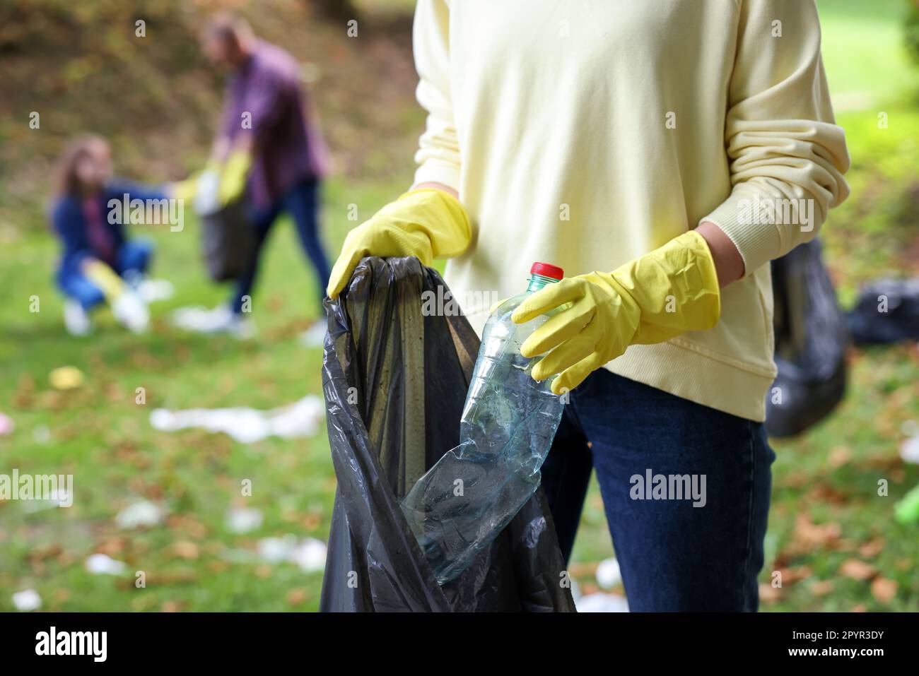 Woman collecting garbage holding bag hi-res stock photography and ...