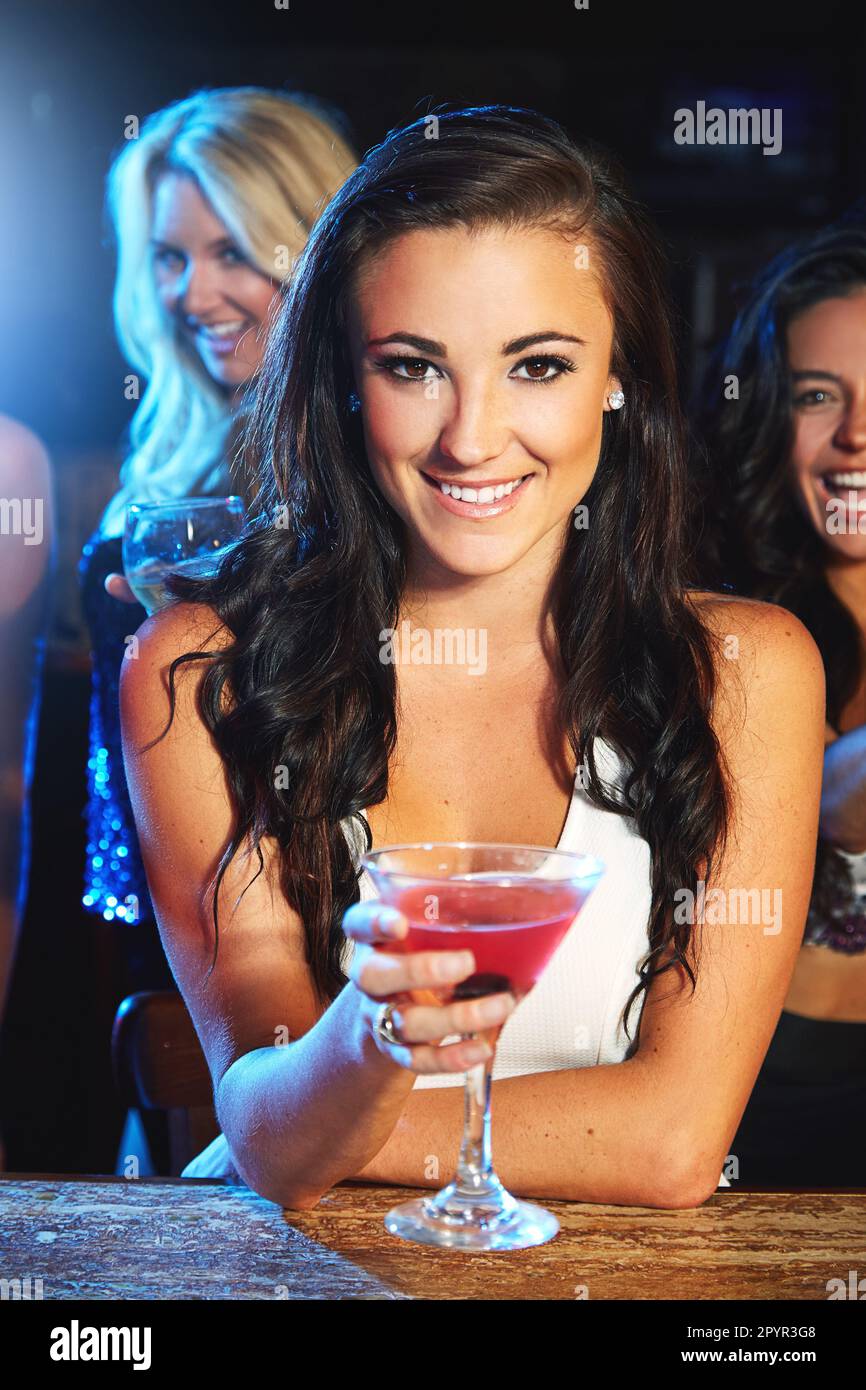 Cocktails after a long week. a young woman partying in a nightclub ...