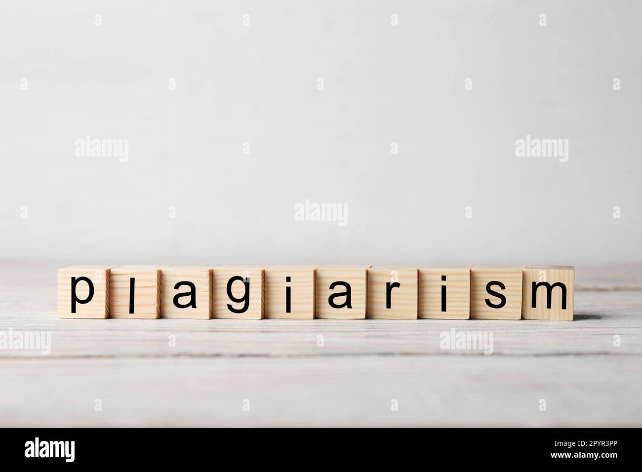 Wooden cubes with word Plagiarism on white table, space for text Stock ...
