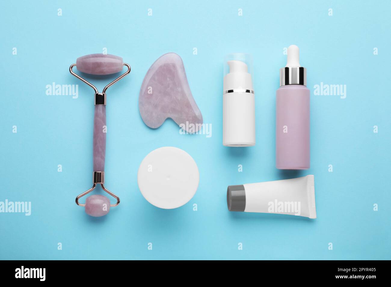 Flat lay composition with gua sha tool and, face roller and skin care ...