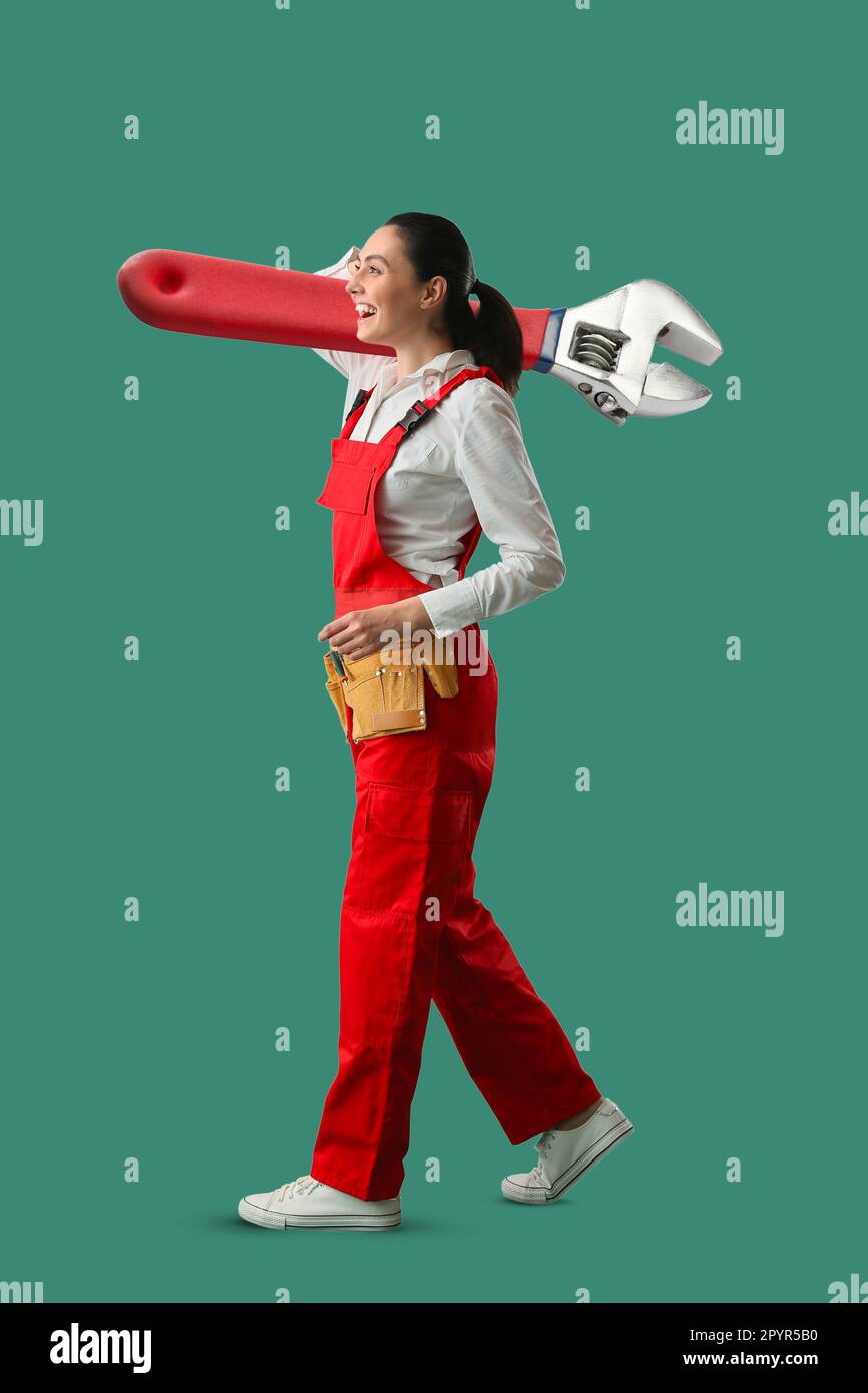 Female worker with big adjustable wrench on green background Stock ...