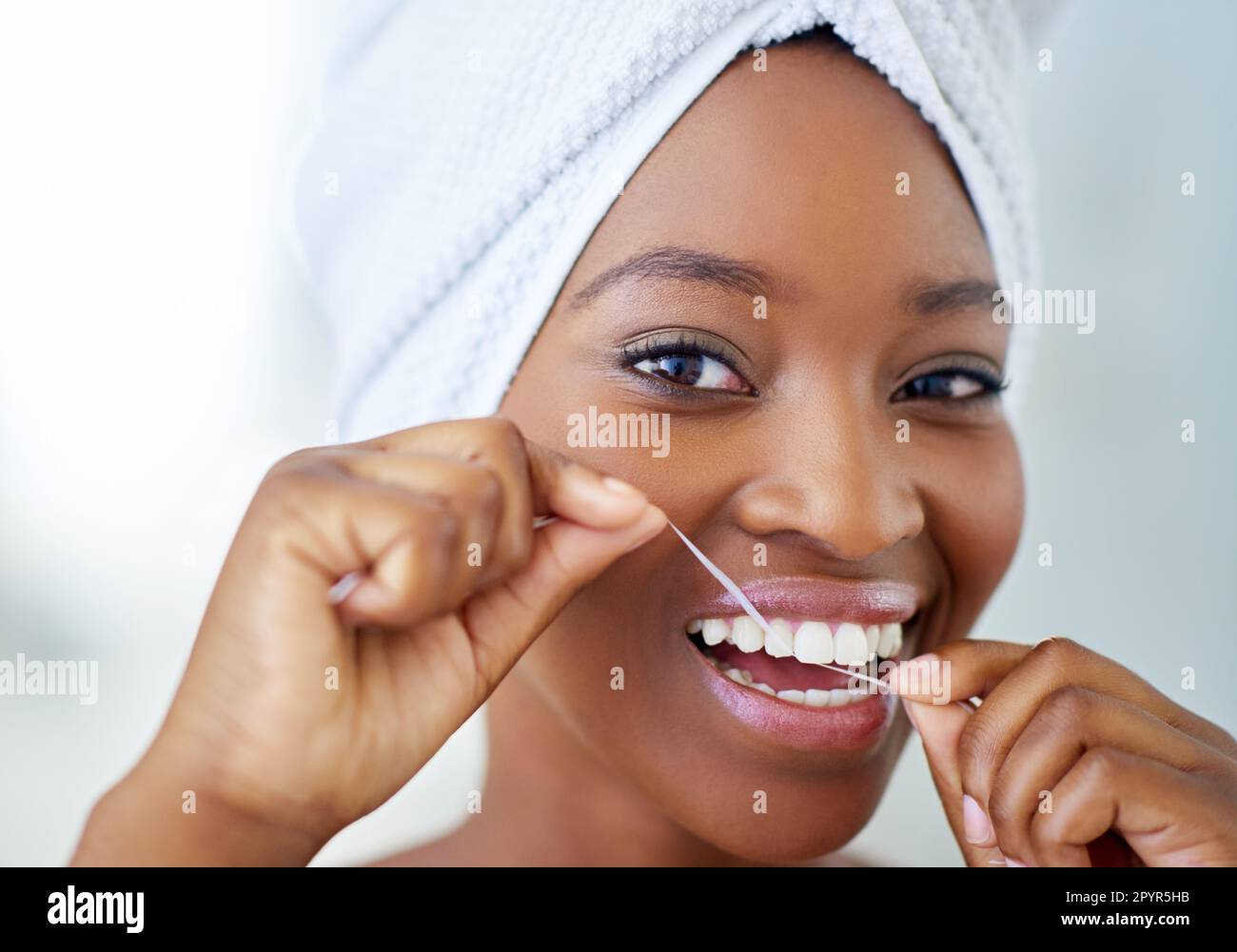 I floss for a whiter and brighter smile. Portrait of an attractive ...