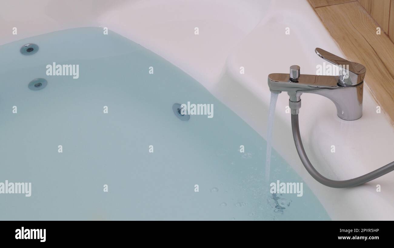 Water running into hot tub in bathroom Stock Photo - Alamy