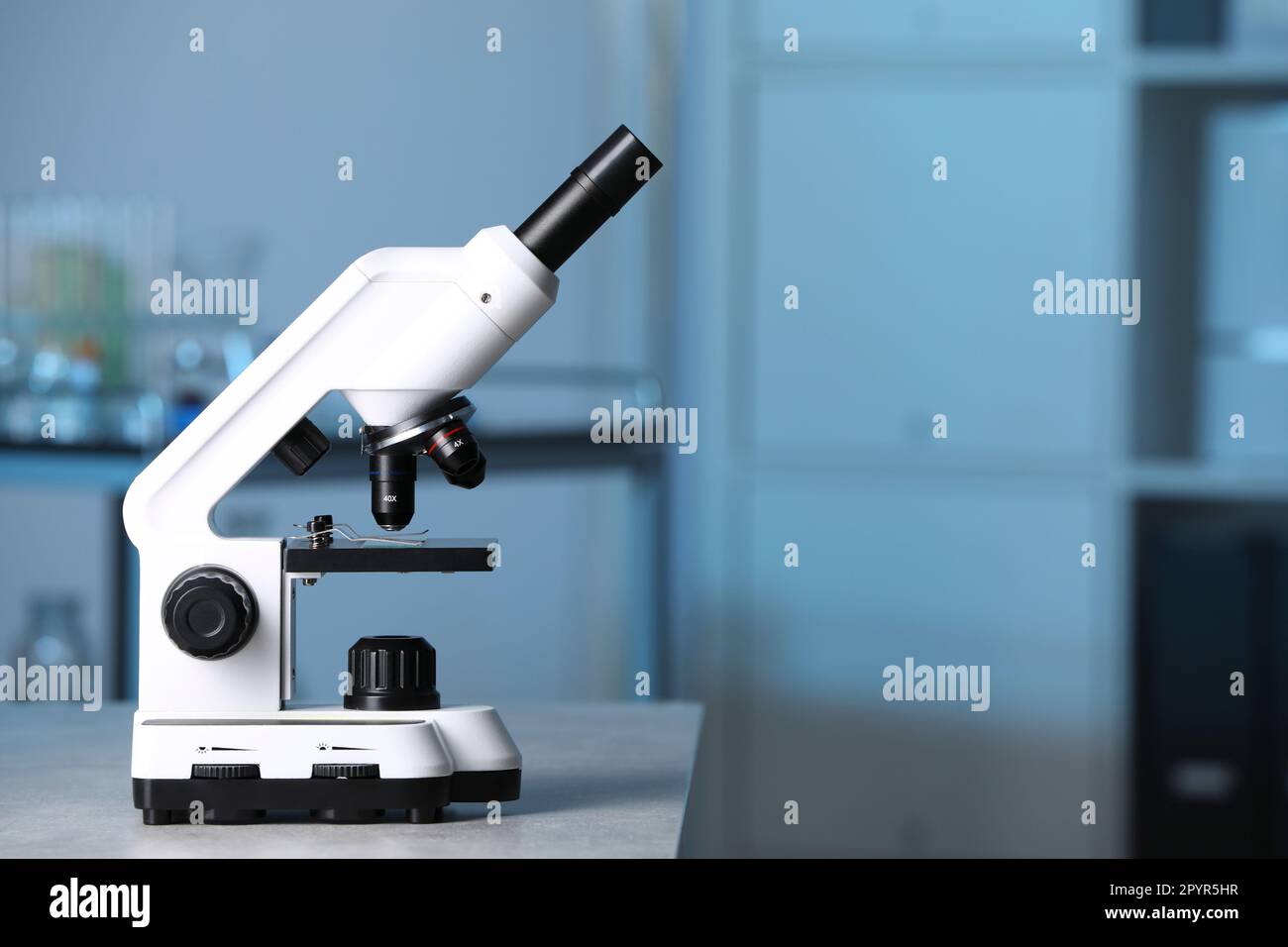 Modern medical microscope on gray table in laboratory, space for text ...