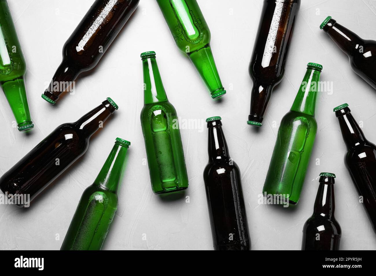 Glass bottles of beer on white background, flat lay Stock Photo - Alamy