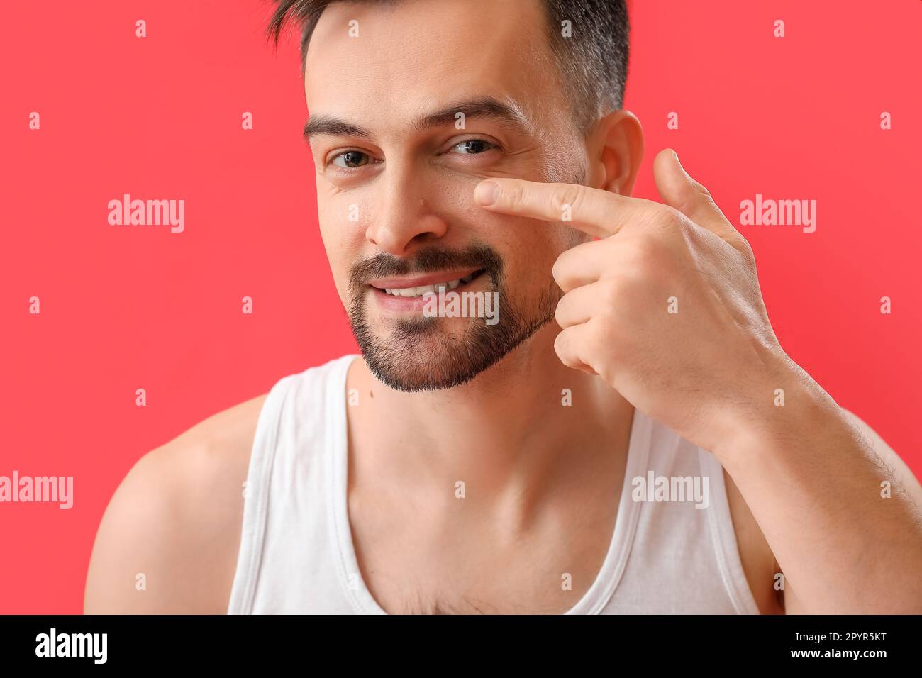 Young man pointing at his mole on red background, closeup Stock Photo ...