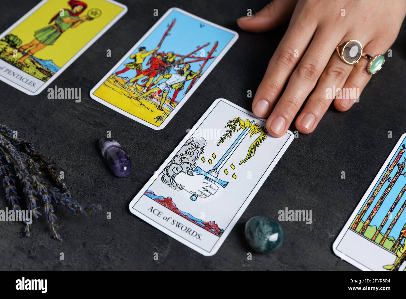Fortune teller predicting future on spread of tarot cards at grey table ...