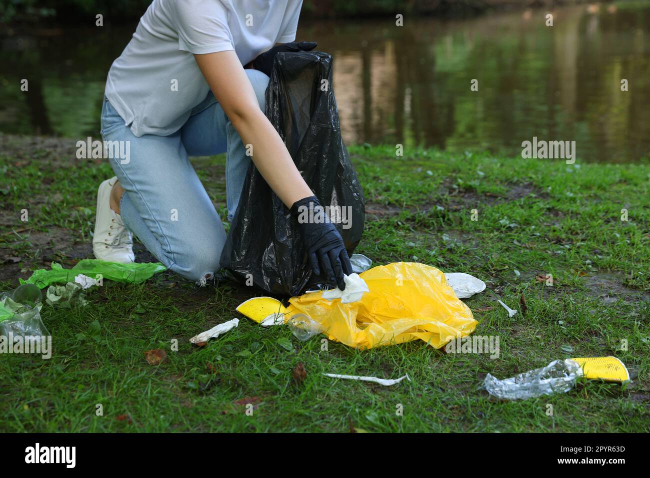Woman with plastic bag collecting garbage in park, closeup Stock Photo ...