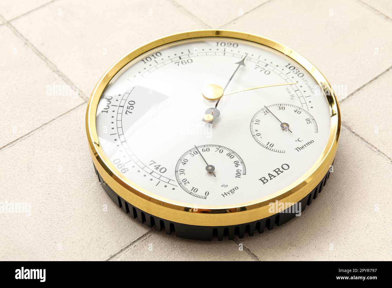 Aneroid barometer on white tiled background Stock Photo - Alamy