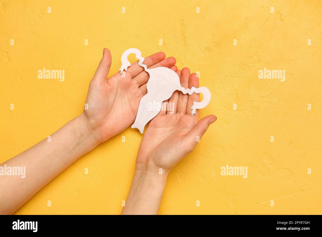 Woman with paper uterus on yellow background. Hormones concept Stock ...
