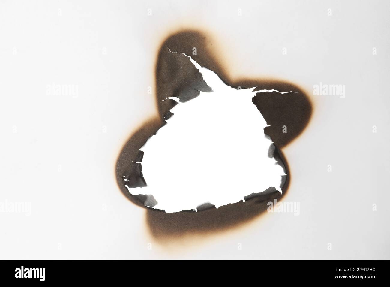 Burnt hole in paper on white background Stock Photo - Alamy