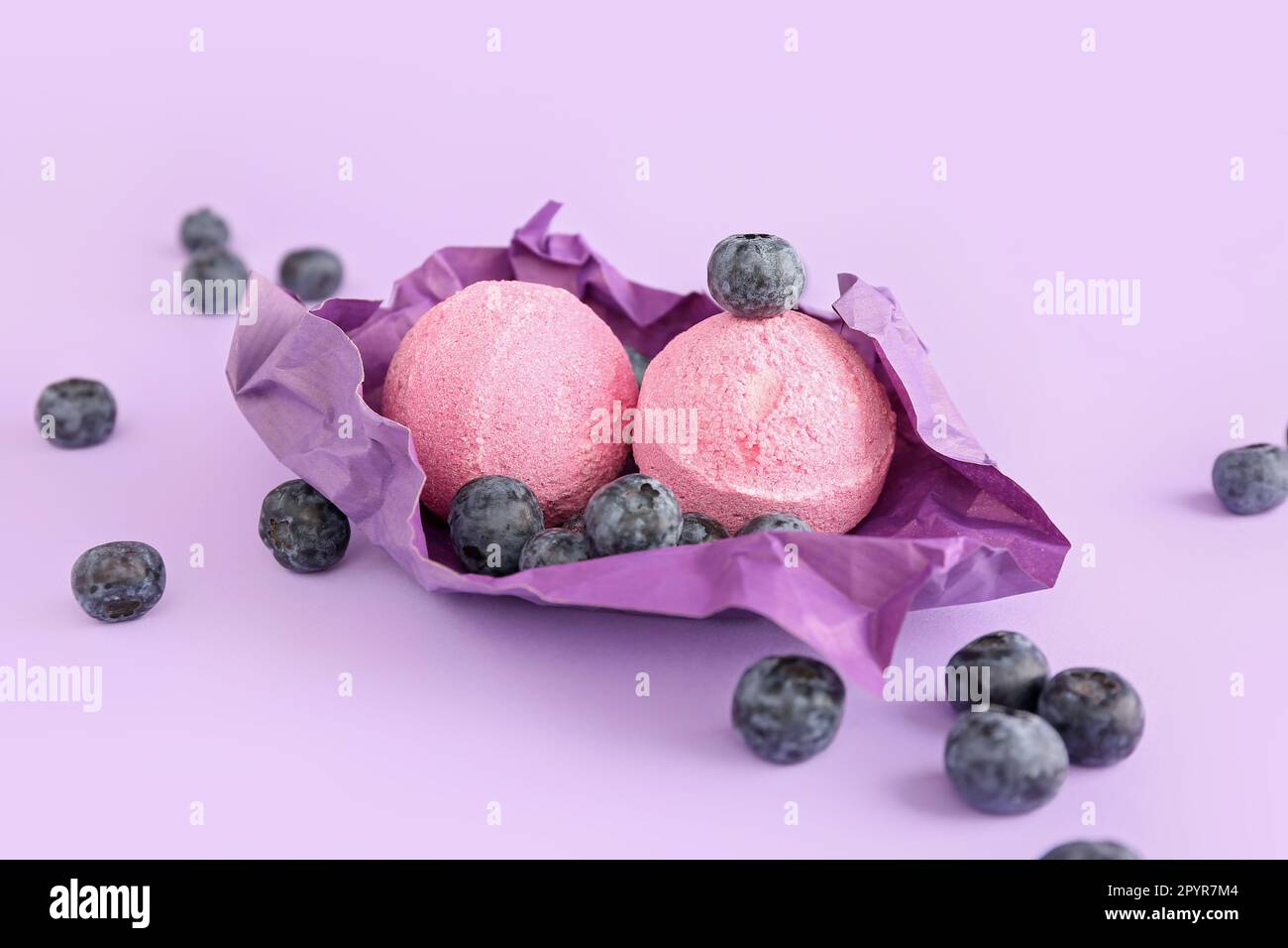 Bath bomb on crumbled paper with blueberry on lilac background Stock ...