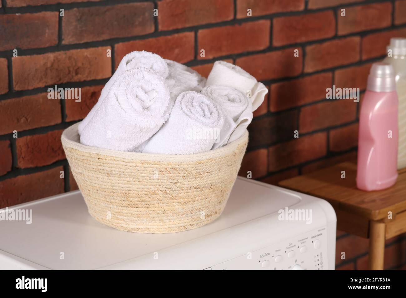 Terry towels in basket on white washing machine indoors. Laundry room ...