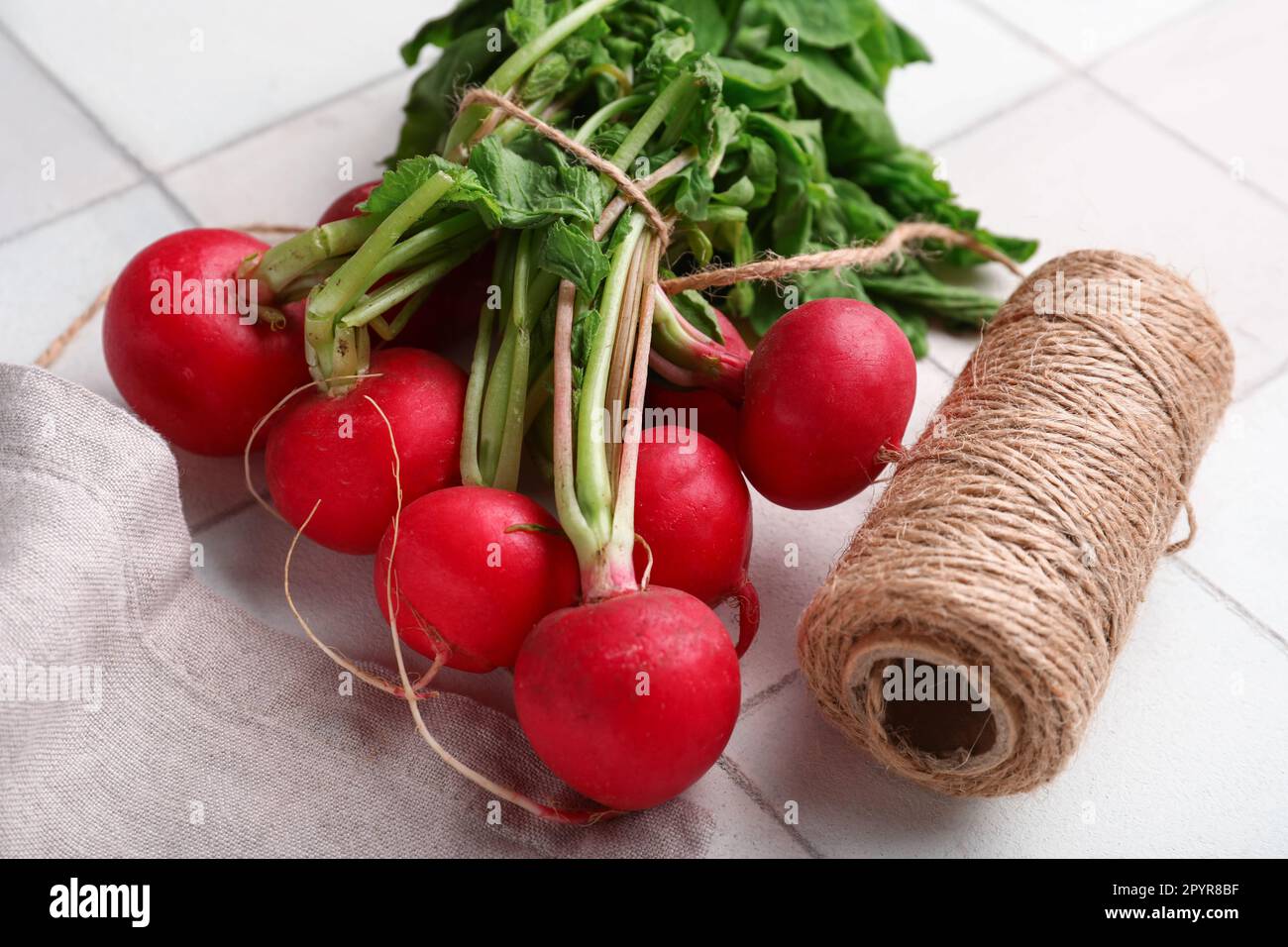 Fresh radishes with leaves on light tile background Stock Photo - Alamy