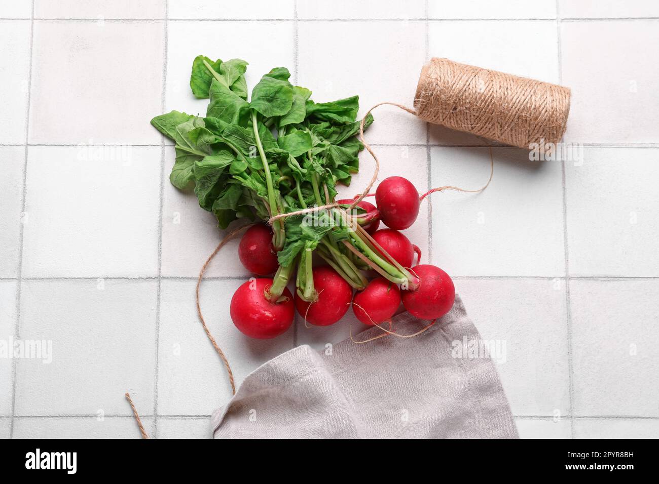 Fresh radishes with leaves on light tile background Stock Photo - Alamy