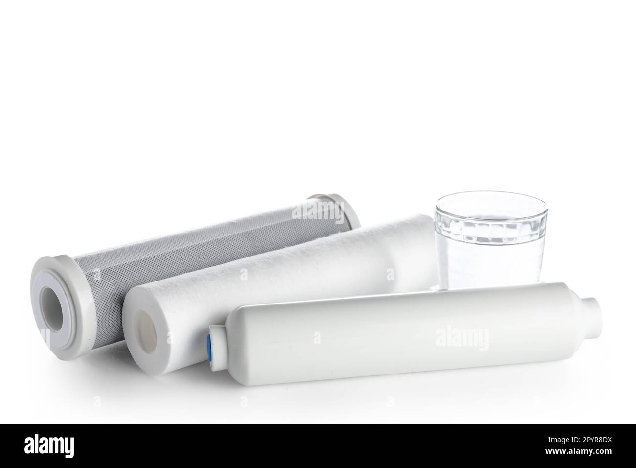 Glass of liquid and water filter cartridges isolated on white ...