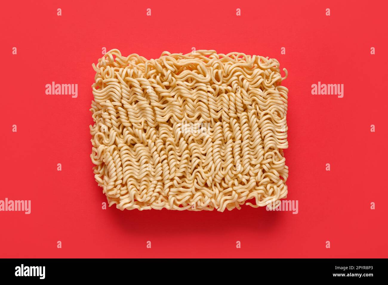 Raw instant noodles on red background Stock Photo - Alamy