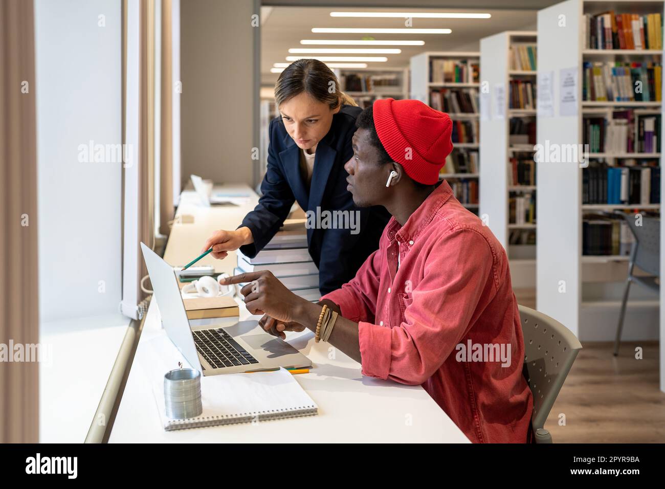 Focused multiracial students couple speak about study project exam with ...