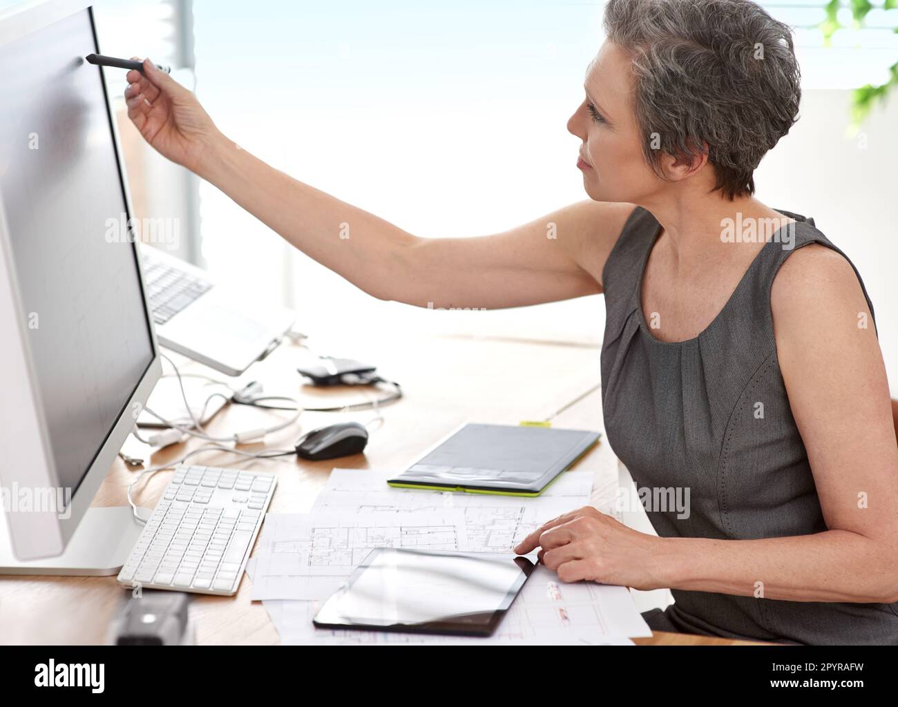 Designs of the future. A mature female architect working on building ...