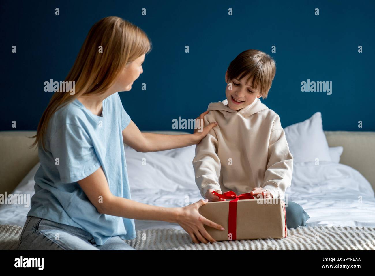 Happy little boy child opening wrapped gift box while celebrating his ...