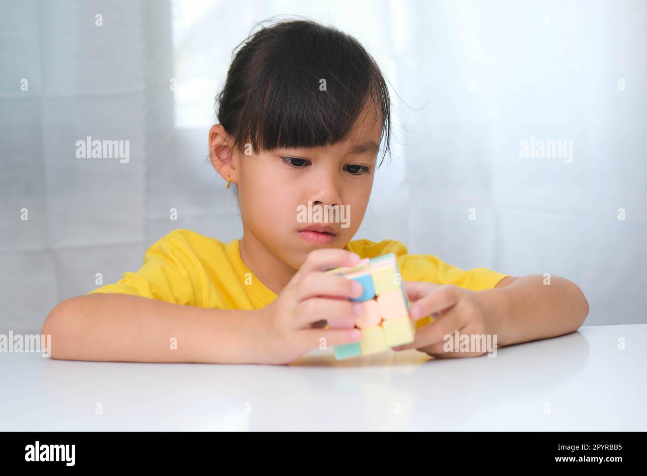 Asian little cute girl holding Rubik's cube in her hands and playing ...