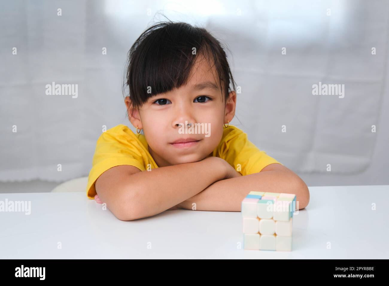 Asian little cute girl holding Rubik's cube in her hands and playing ...