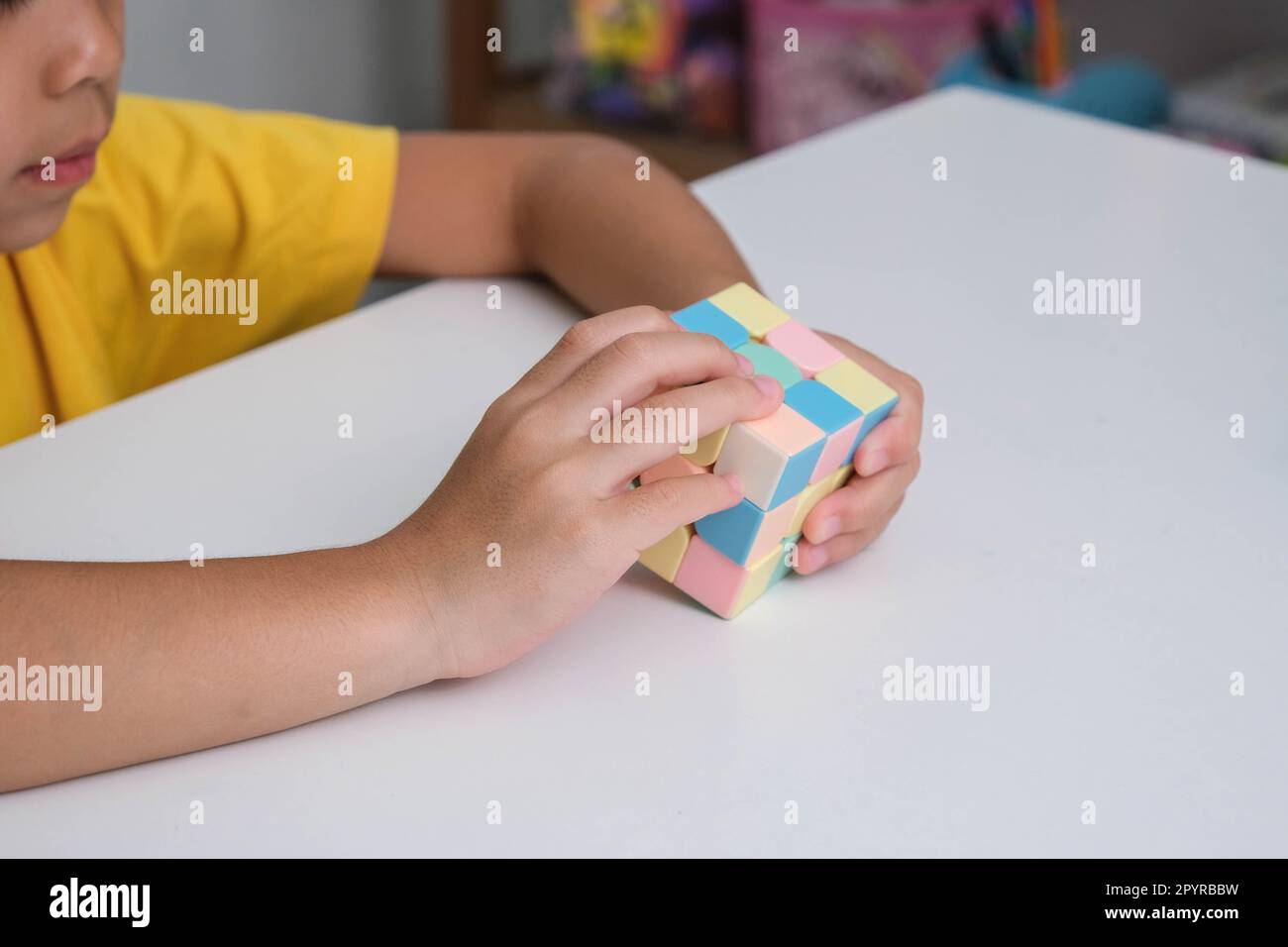 Asian little cute girl holding Rubik's cube in her hands and playing ...