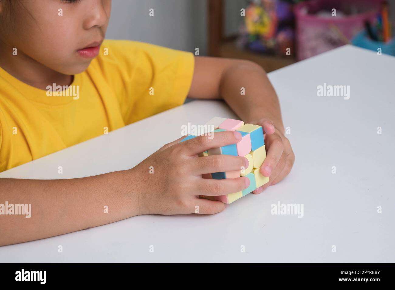 Asian little cute girl holding Rubik's cube in her hands and playing ...