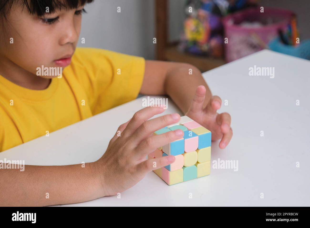 Asian little cute girl holding Rubik's cube in her hands and playing ...