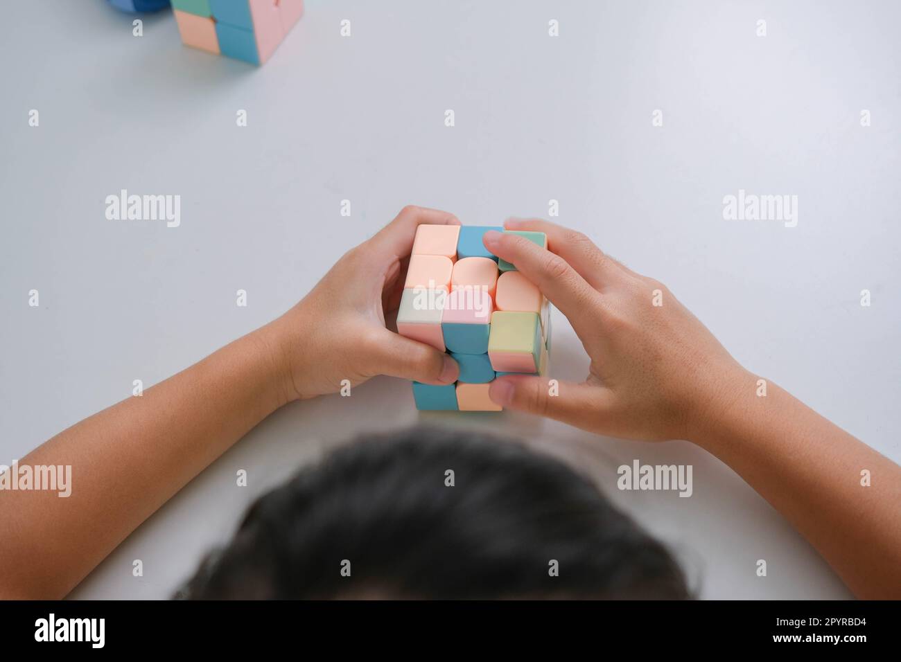Asian little cute girl holding Rubik's cube in her hands and playing ...