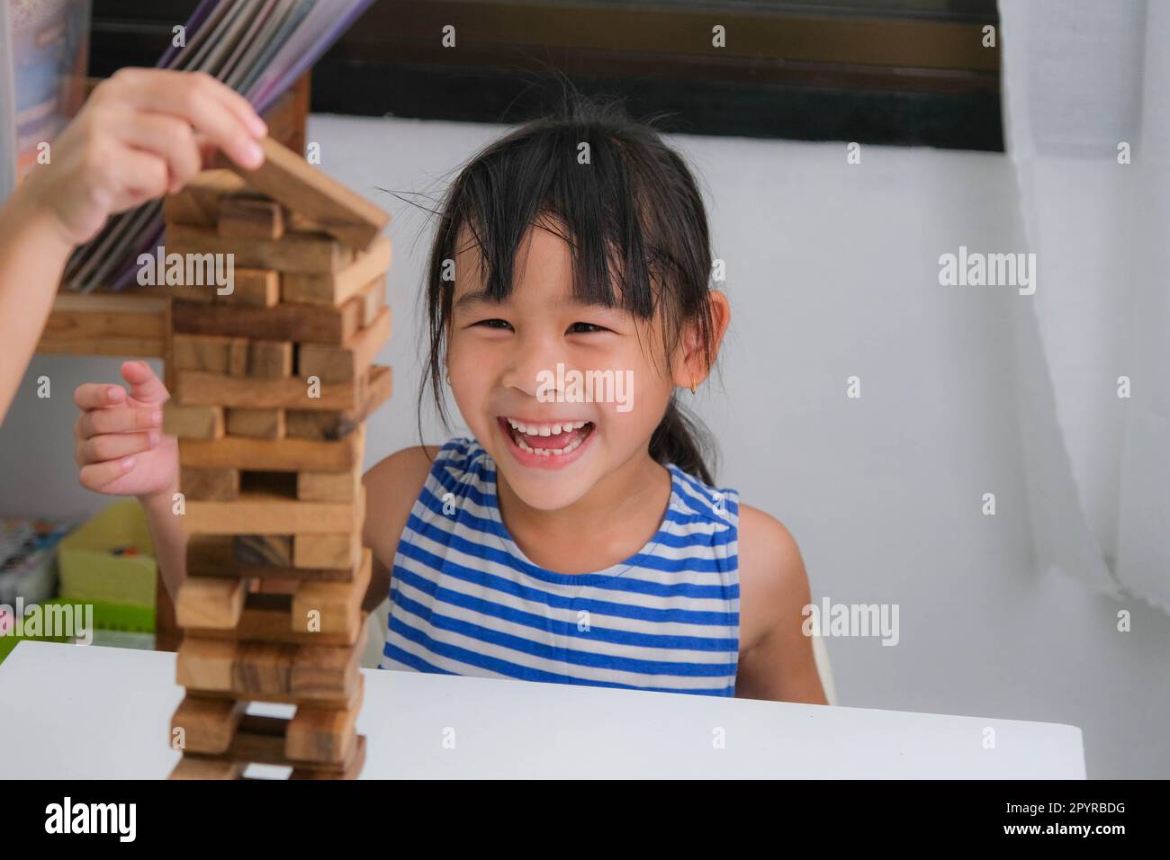 Cute Asian siblings having fun playing Jenga together. Two children ...