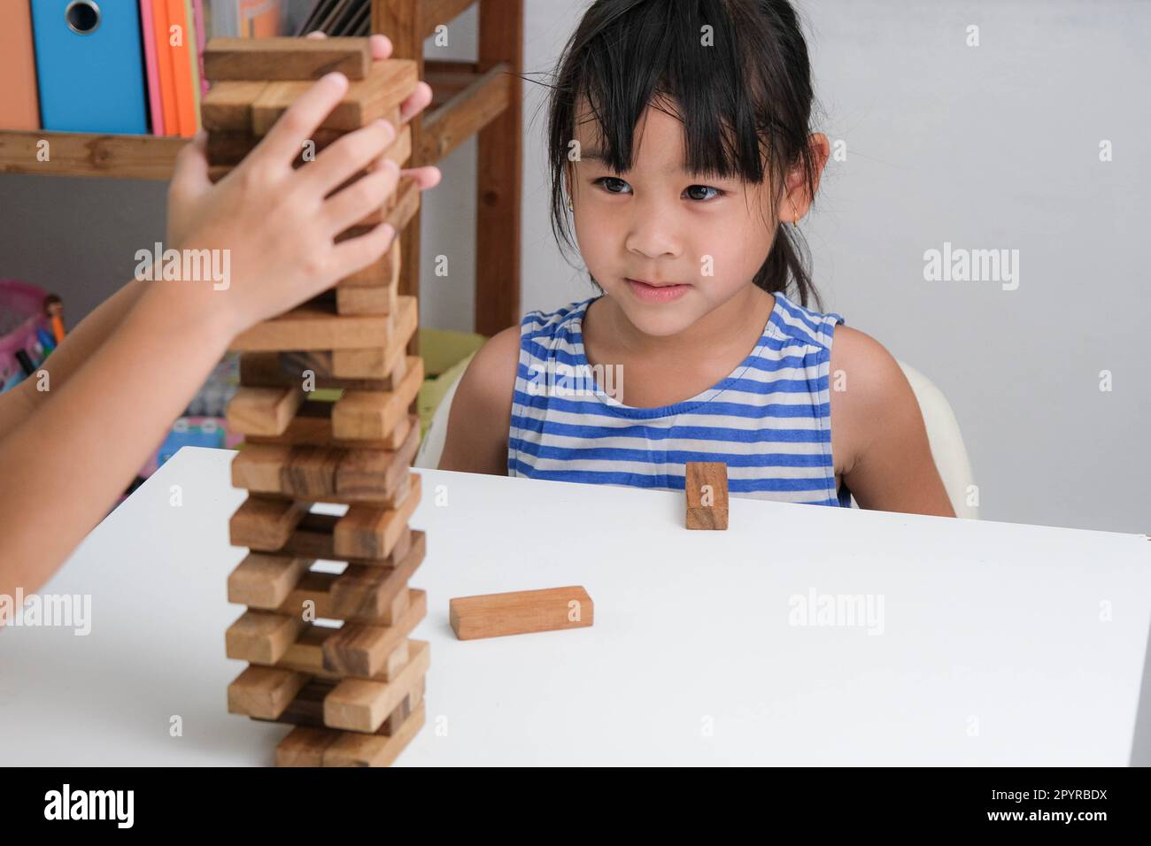 Cute Asian siblings having fun playing Jenga together. Two children ...