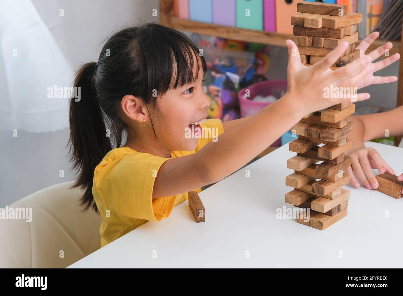 Cute Asian siblings having fun playing Jenga together. Two children ...