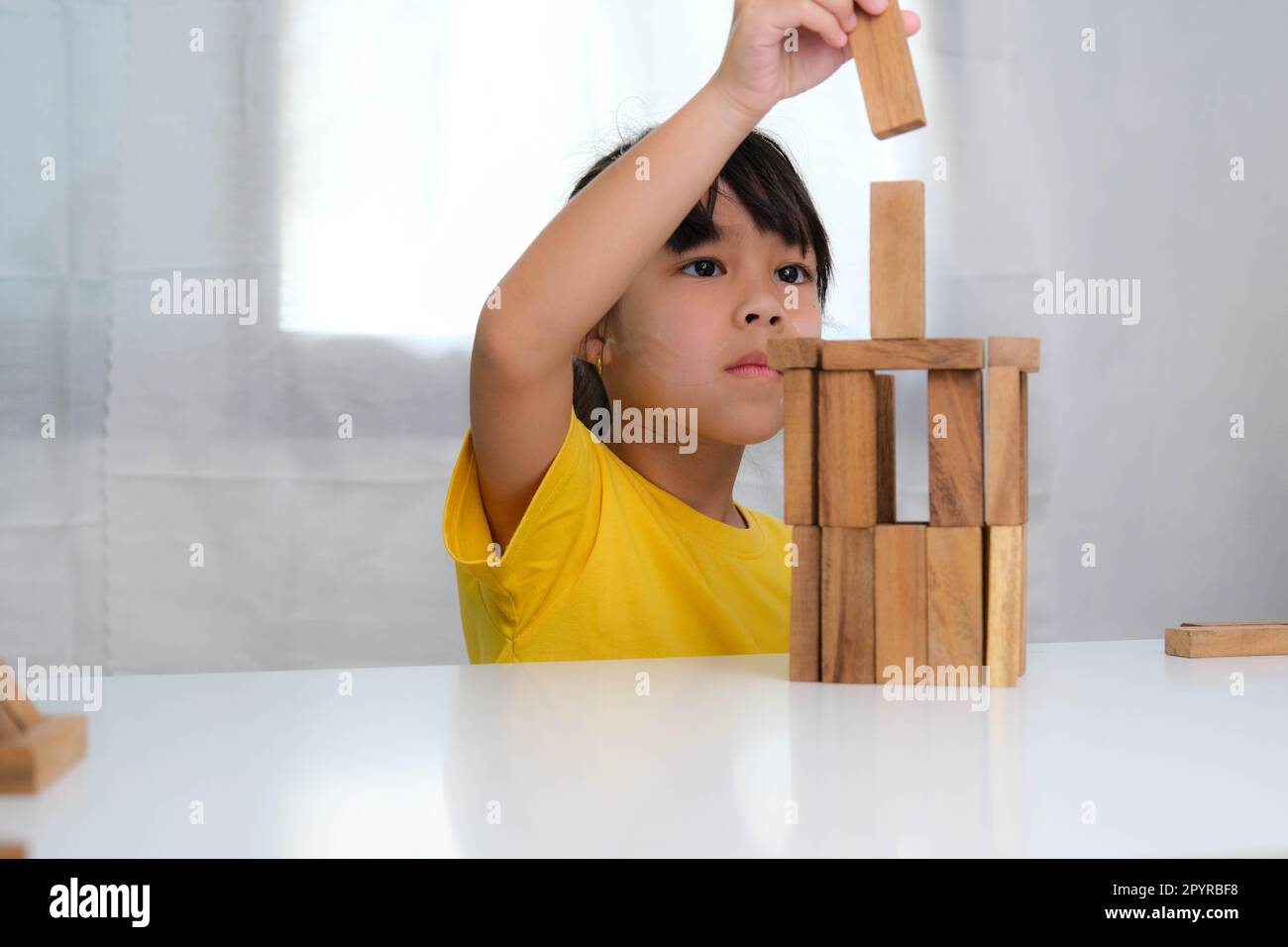 Asian cute little girl playing with constructor wooden block building ...