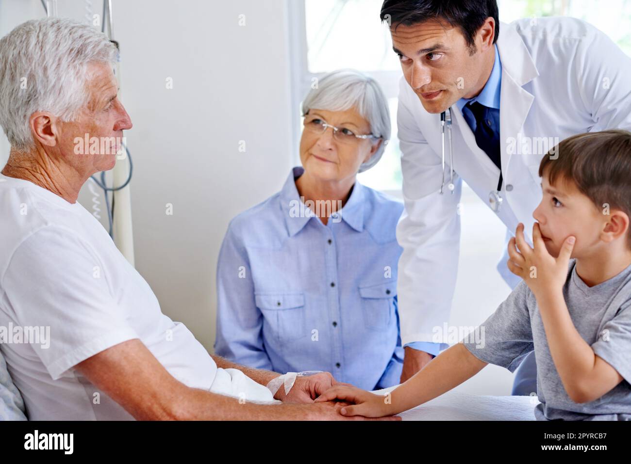 By his side through difficult times. a sick man in a hospital bed ...
