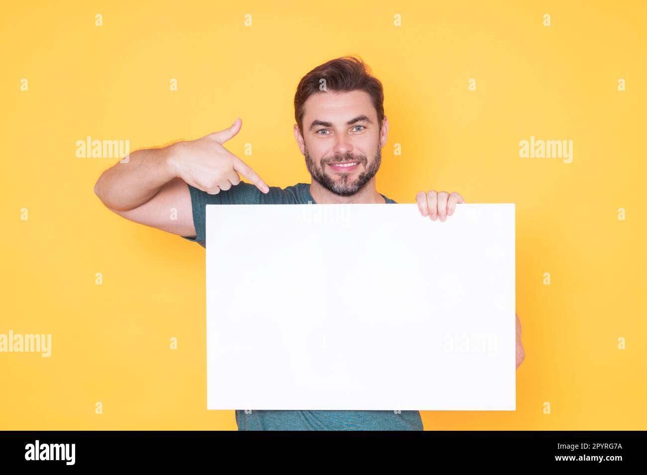 Man with blank banner isolated on studio background. Portrait of ...