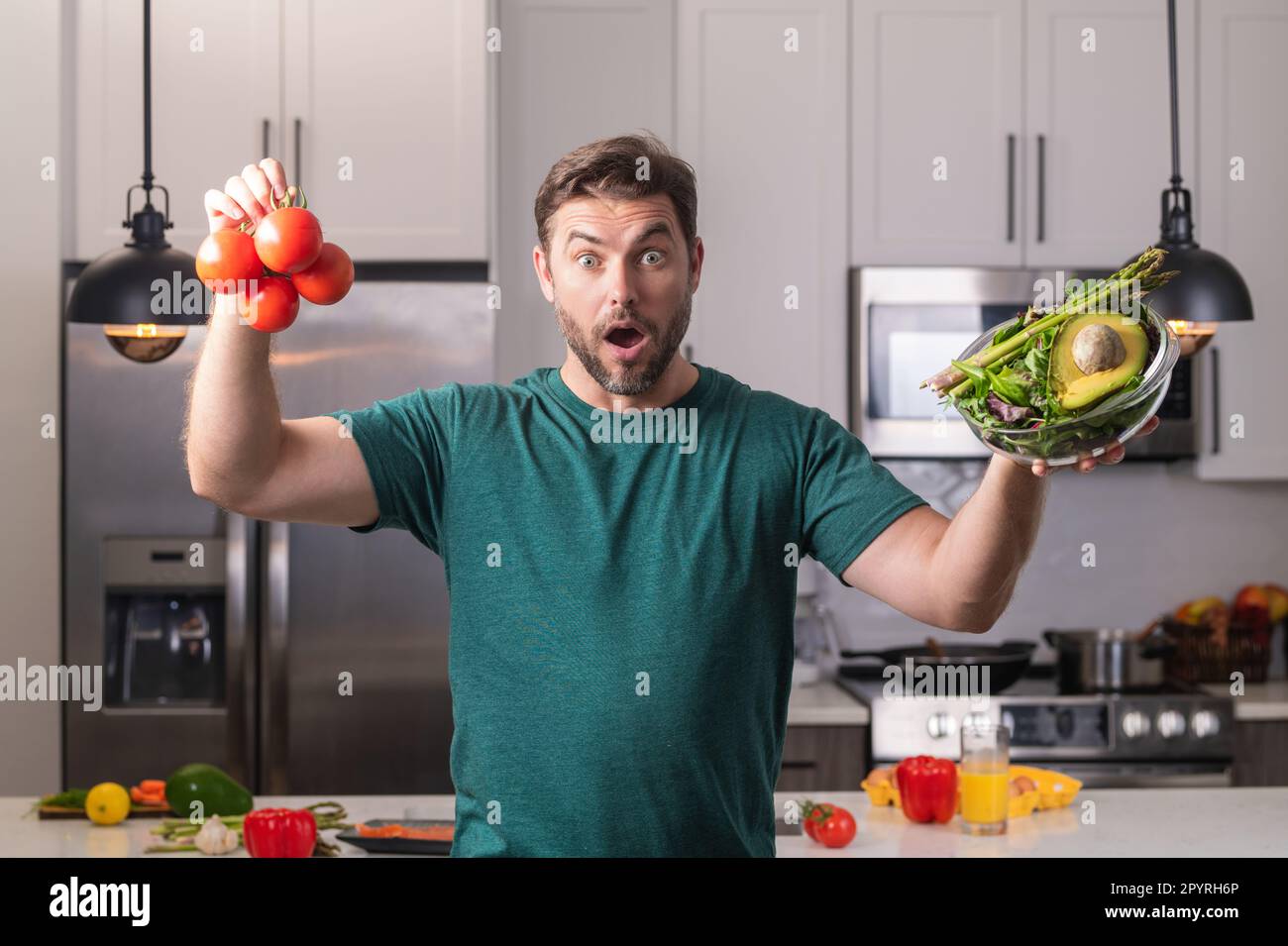 Middle aged man cooking in kitchen. Man on kitchen with vegetables ...