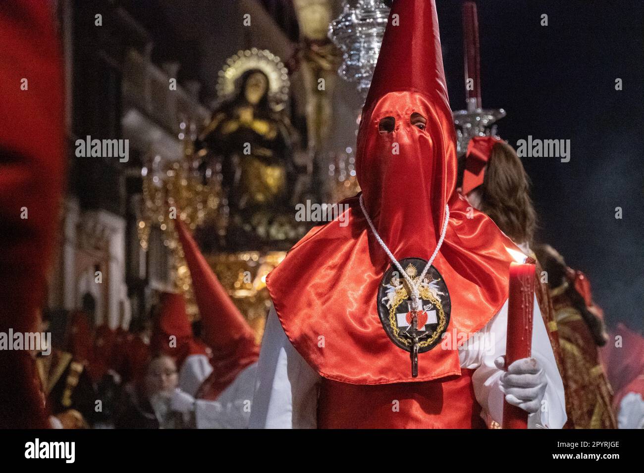 Cofradias wearing red cone shaped hoods lead a giant platform with the ...