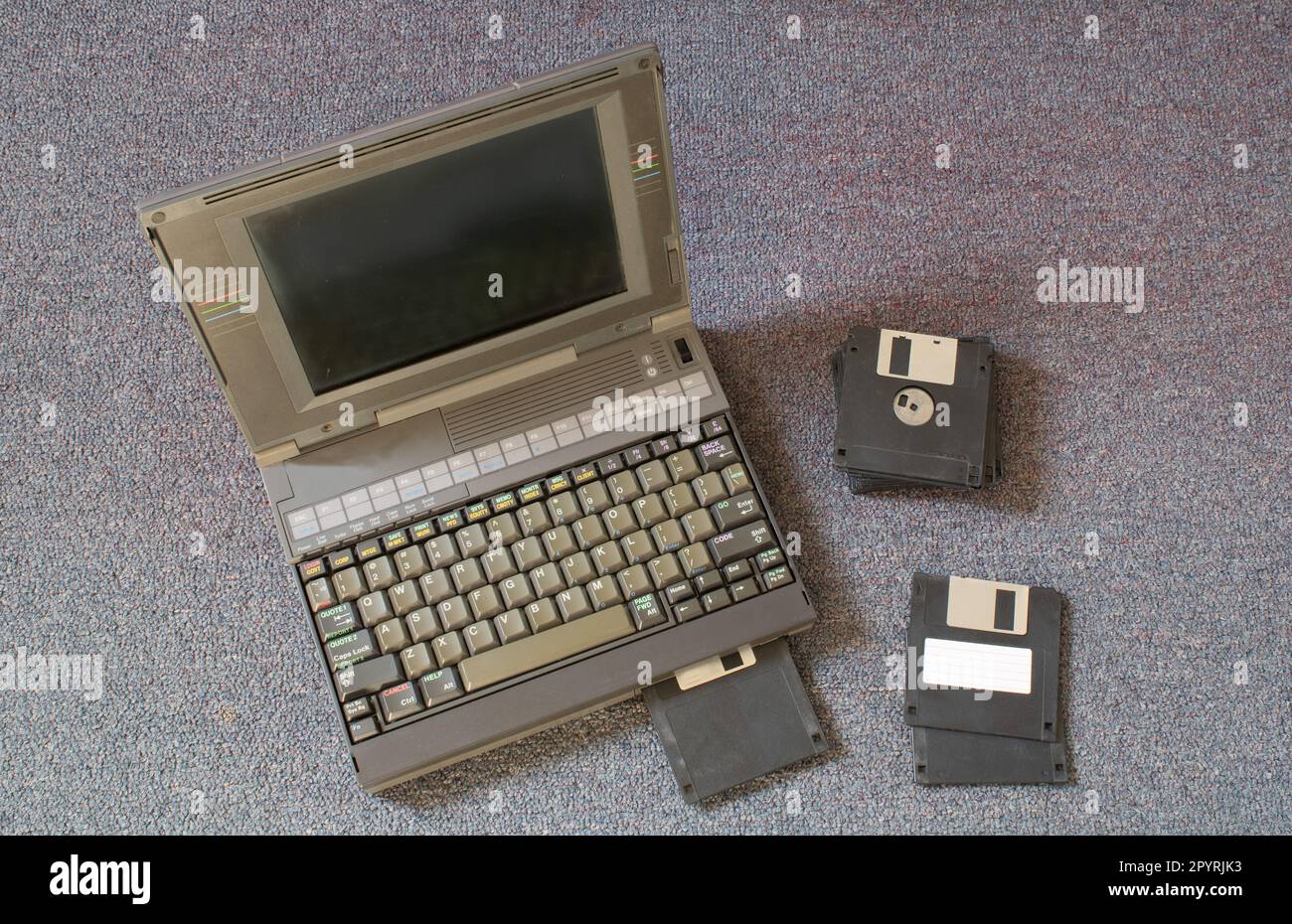 hands of a person taking a floppy disk and placing it inside an old ...