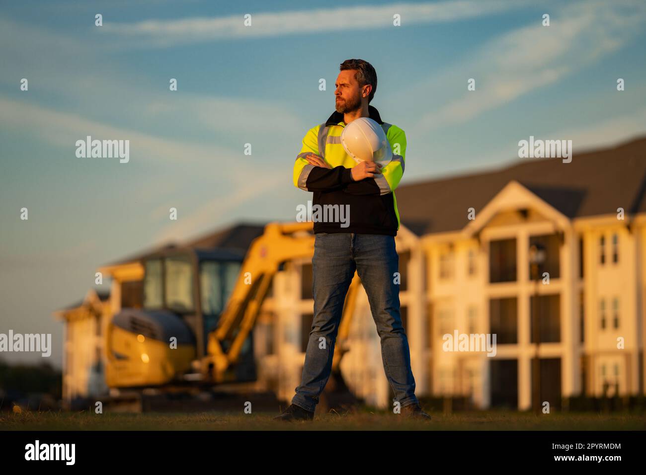 Builder in a construction site. Builder with excavator ready to build ...